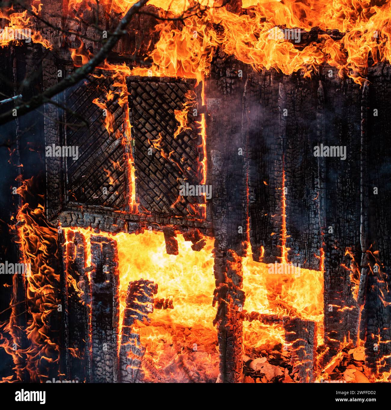 A fire destroys a charred burnt house. Charred in flame house at night ...