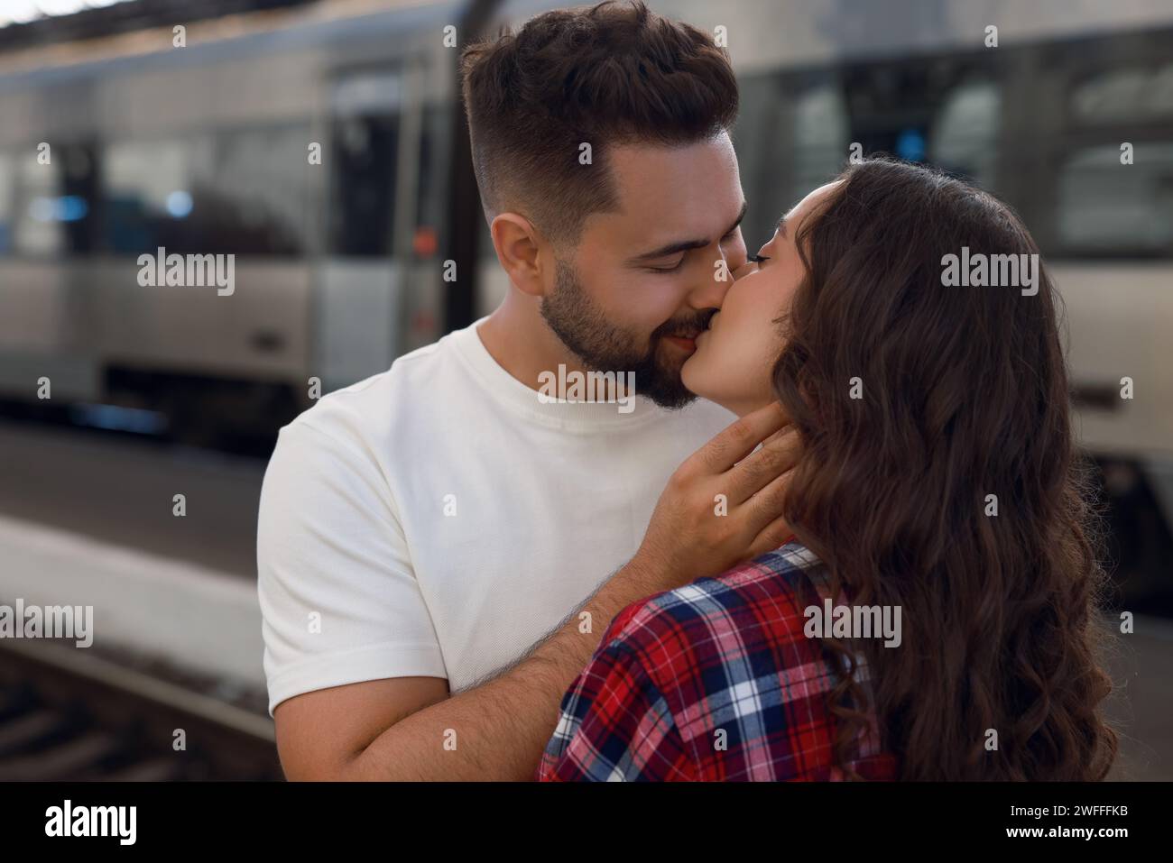 Long-distance relationship. Beautiful couple kissing on platform of railway station Stock Photo ...