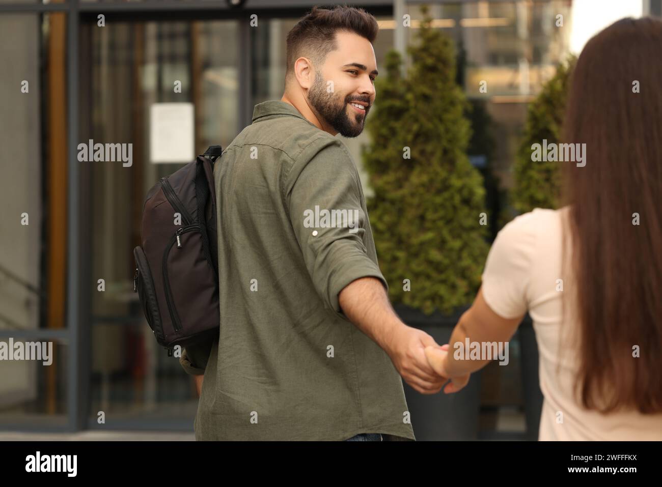 Long-distance relationship. Man with backpack holding hands with his ...