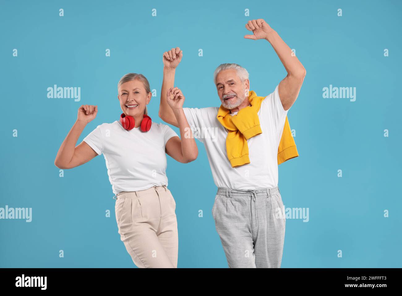 Senior couple dancing together on light blue background Stock Photo - Alamy