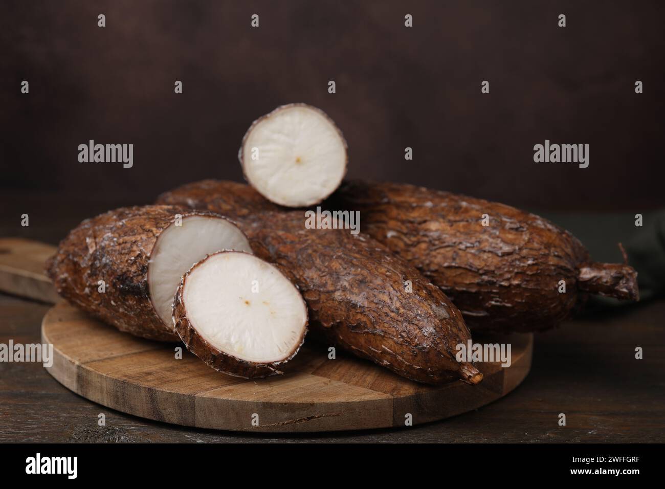 Whole and cut cassava roots on wooden table Stock Photo - Alamy