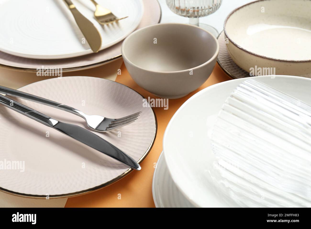 Clean plates, bowls, glass and cutlery on table Stock Photo - Alamy