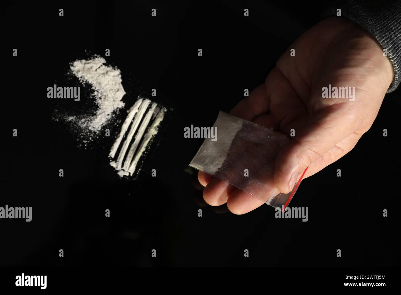 Drug addiction. Man with cocaine at black table, top view Stock Photo ...