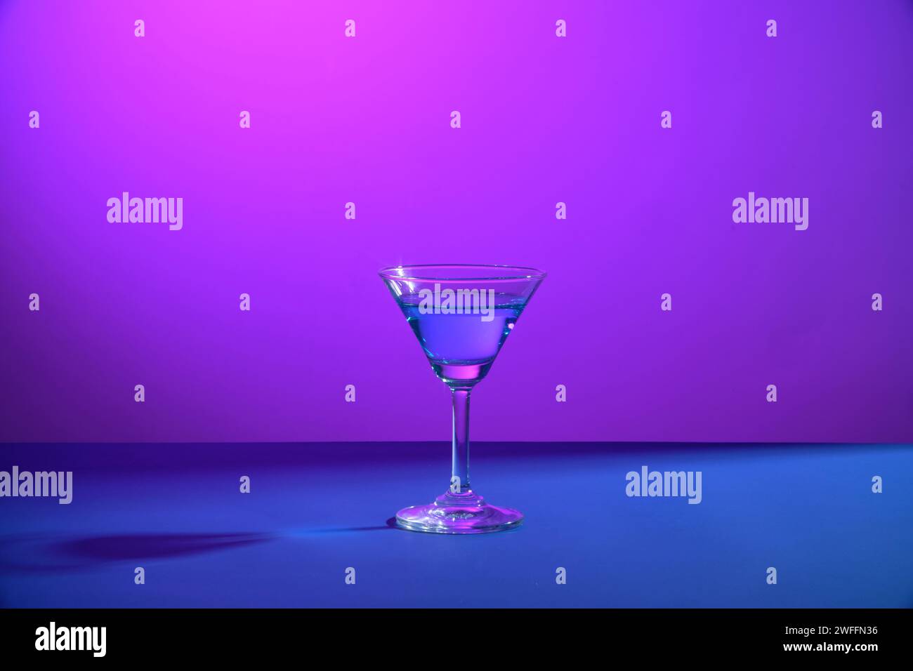 Martini cocktail glass filled with beverage isolated on gradient purple ...