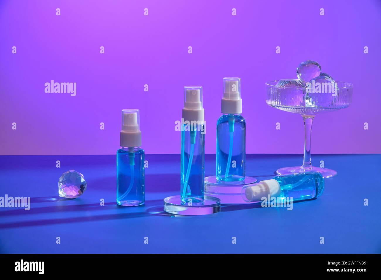 Several mist spray bottles placed on transparent podium, displayed with ...