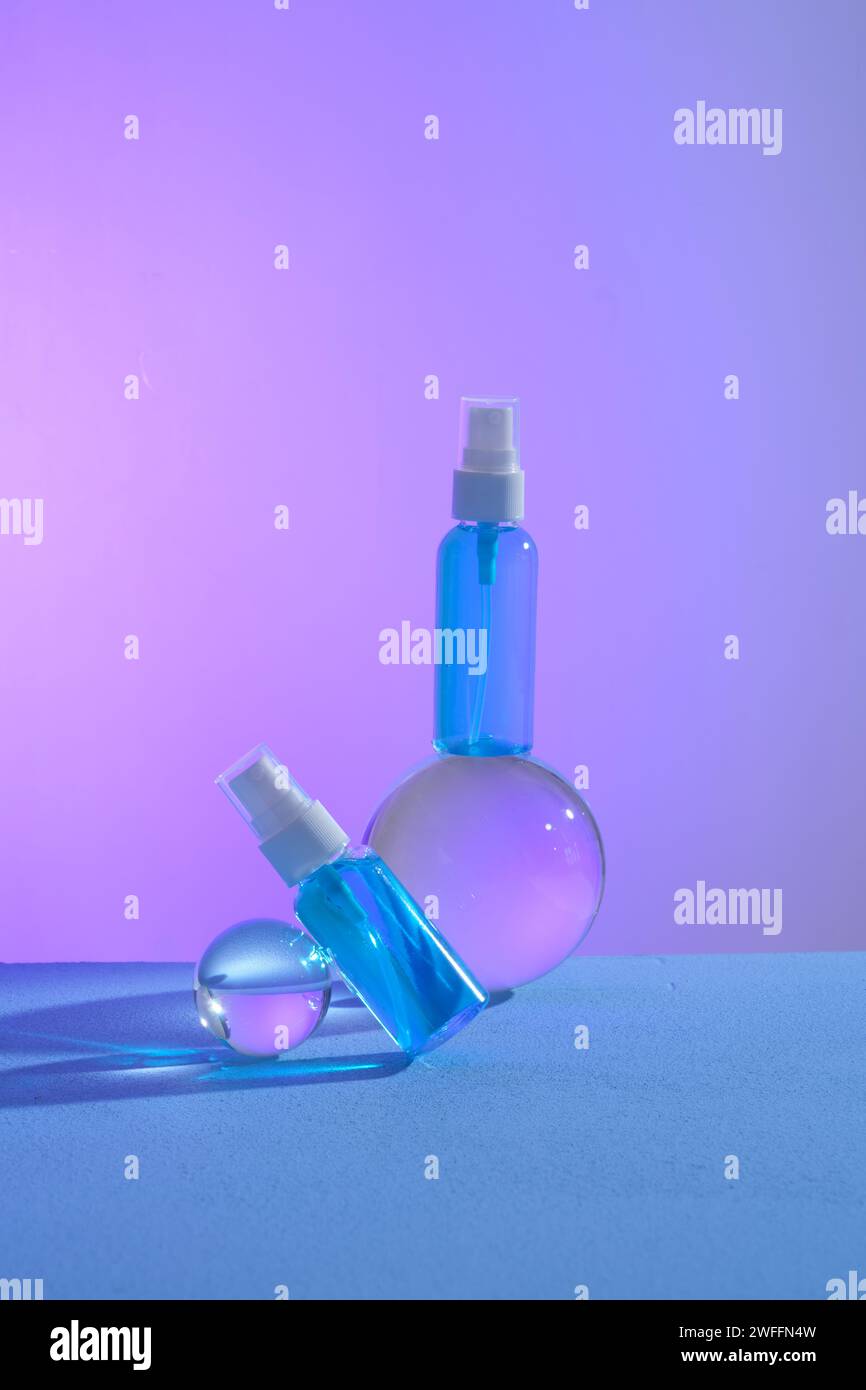 A mist spray bottle placed on a big transparent ball and another one is ...