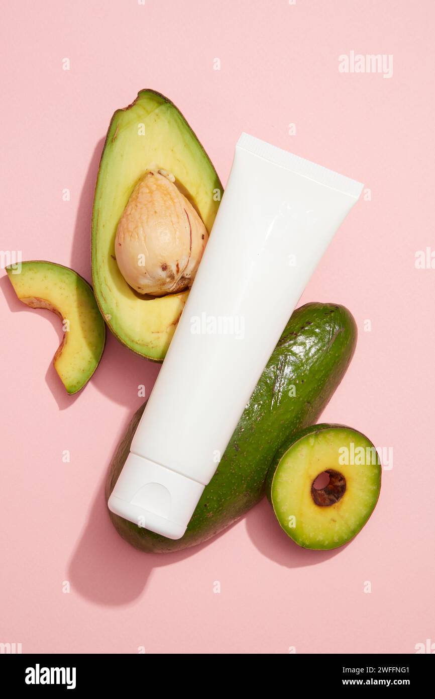 A white tube placed on Avocado slices. Blank label for beauty products ...