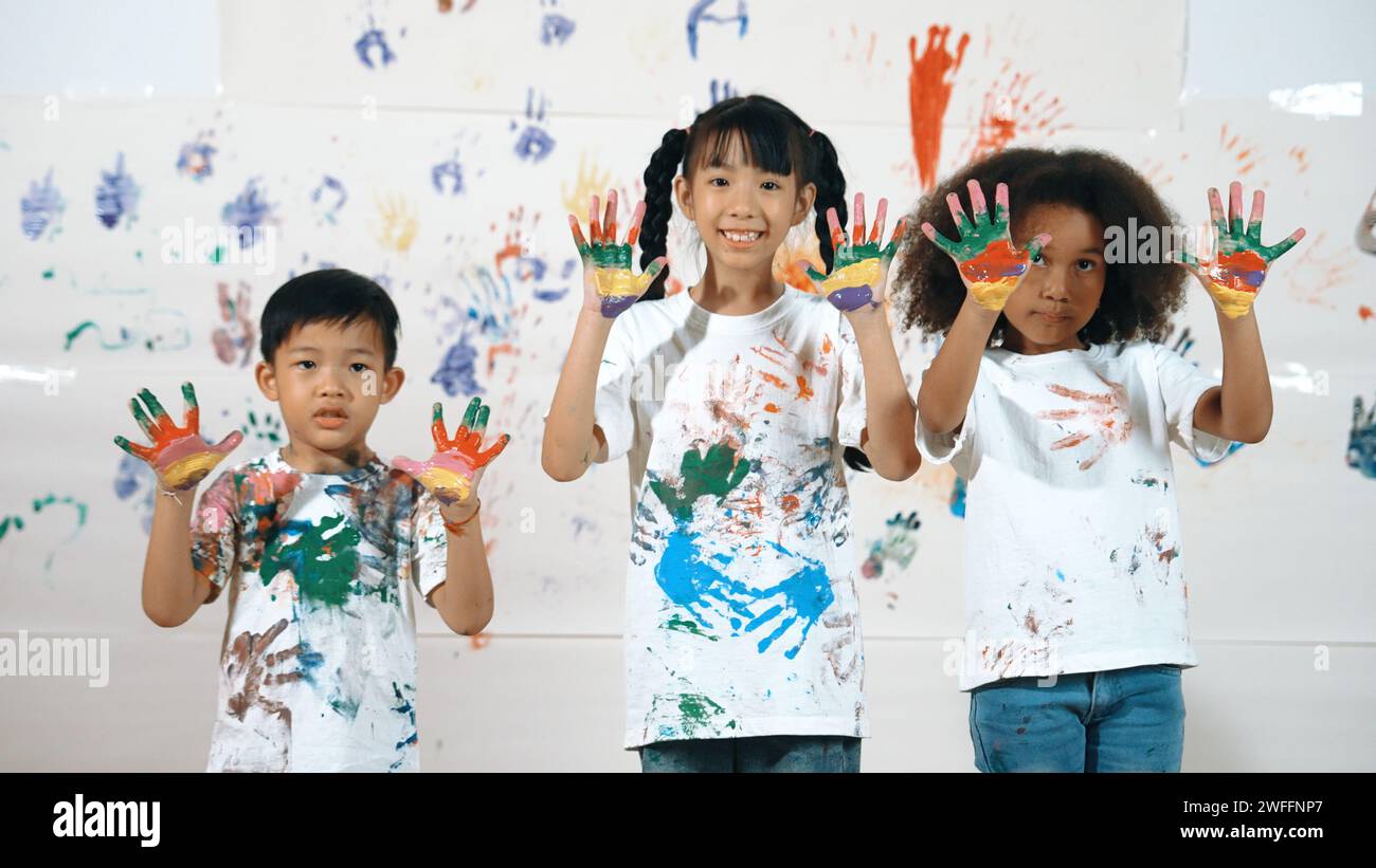 Diverse students put hands up together show colorful stained hands ...
