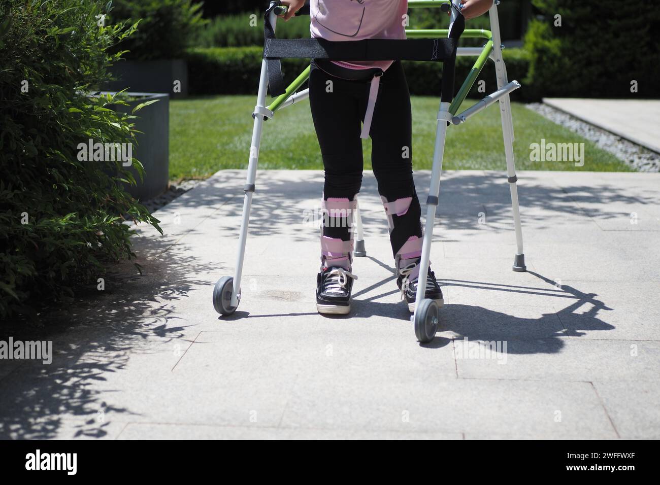child with walking frame and knee orthosis outdoor Stock Photo - Alamy