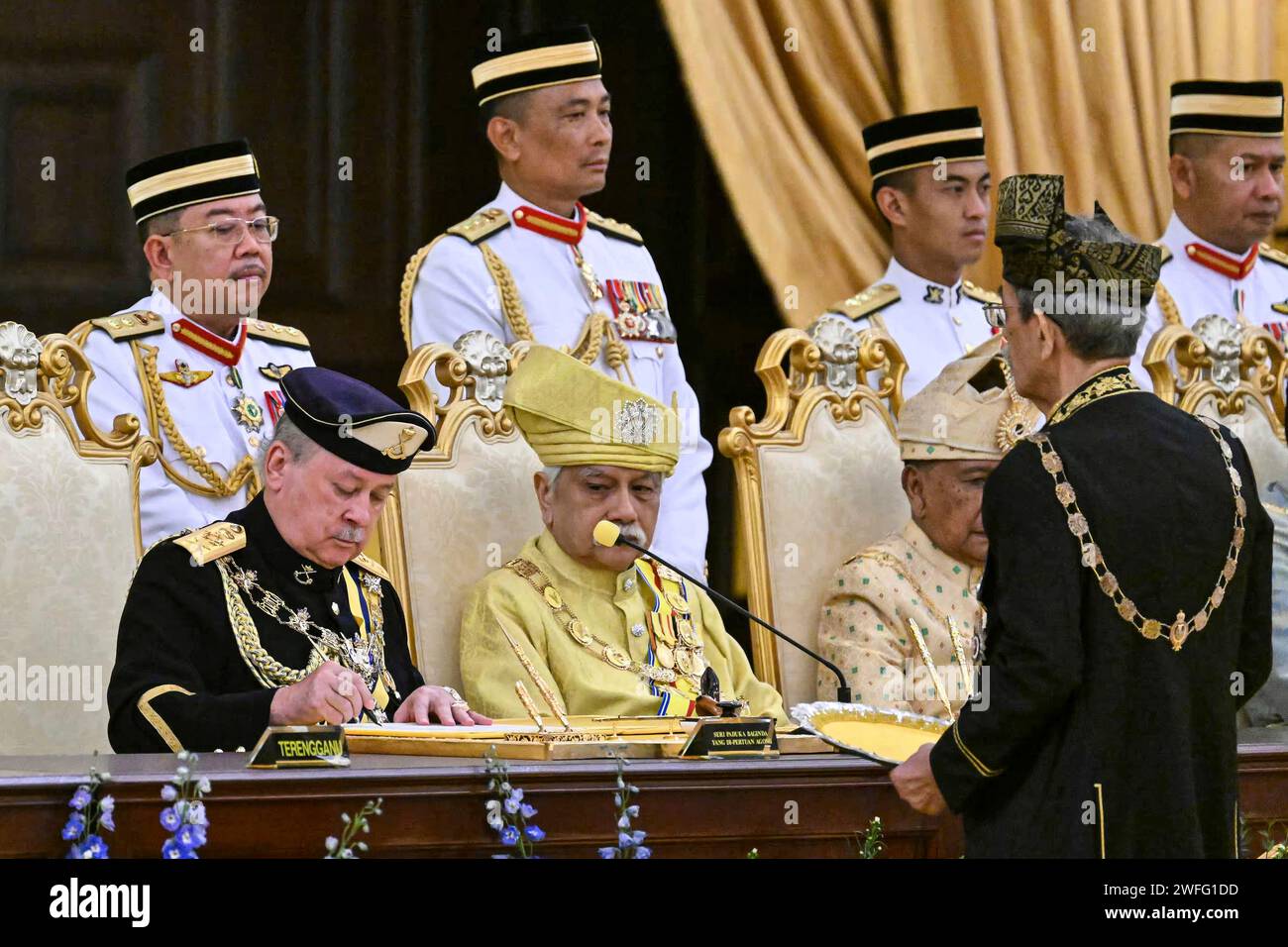 Sultan Ibrahim Sultan Iskandar, front left, signs documents during the oath taking ceremony as ...