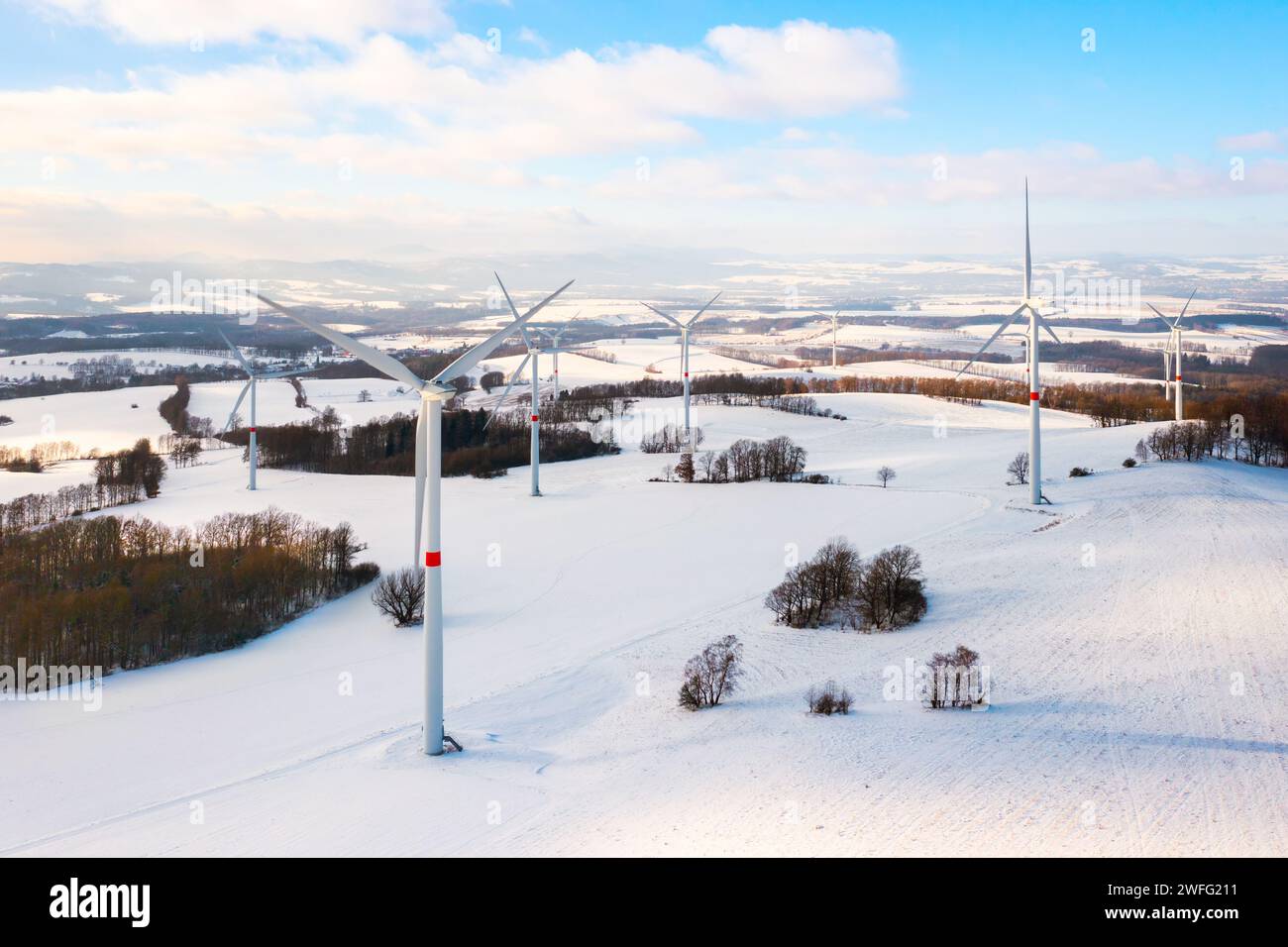 Panoramic view of a wind turbine park in the winter field as a hub of ...