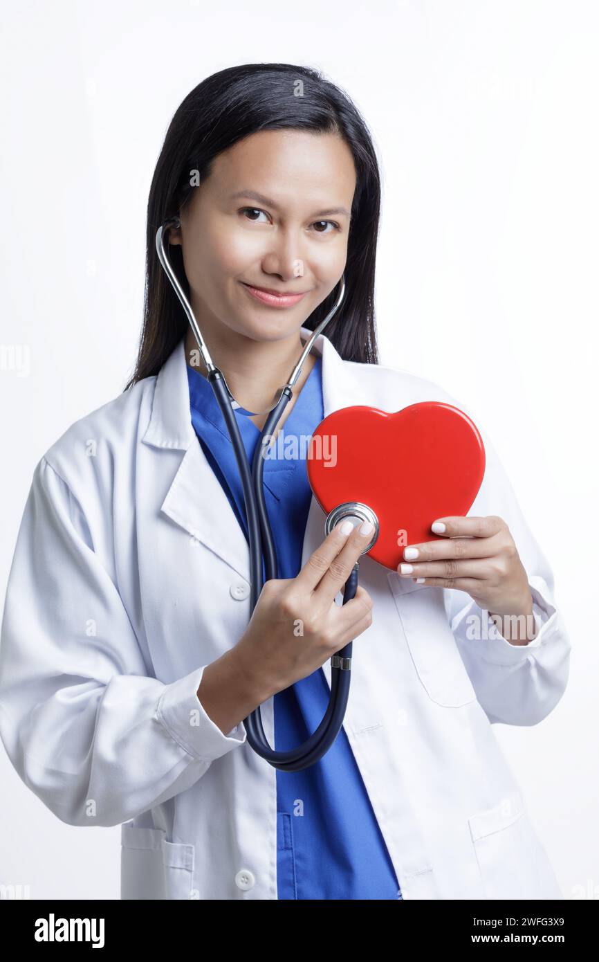 Asian American Woman Doctor examining a Red Heart concept 0f Love of ...
