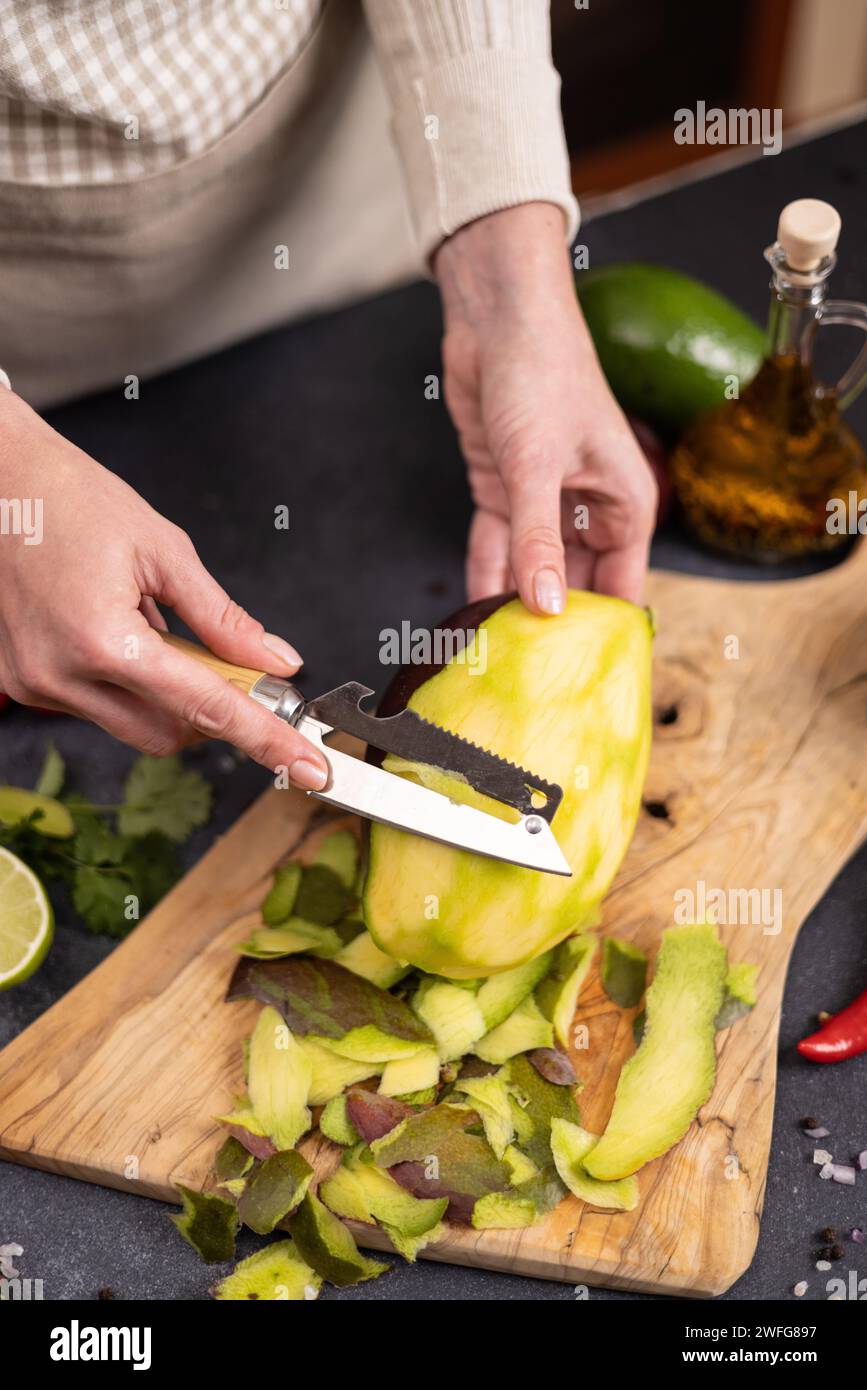 Cooking mango salsa - woman peeling mango fruit Stock Photo - Alamy
