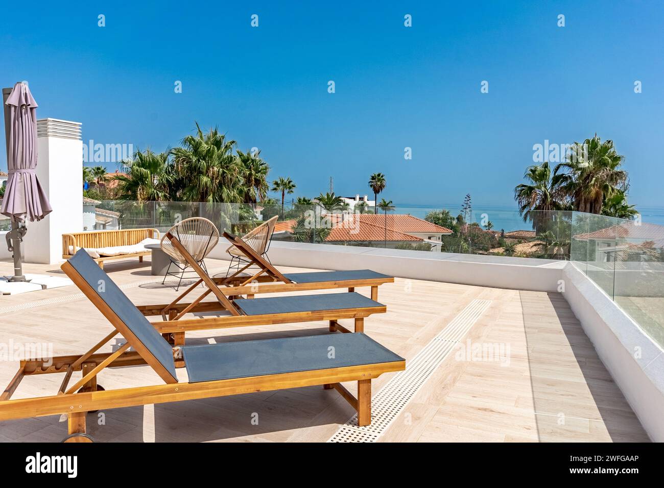 a set of sun lounges with sea views on a luxury rooftop terrace in ...