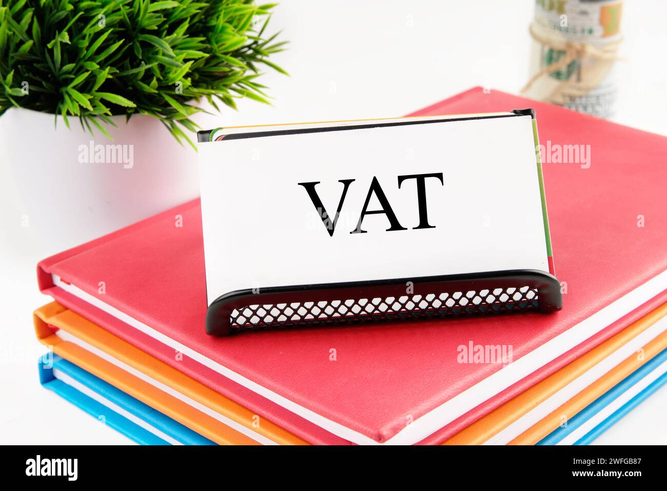 VAT text on a white business card standing on a stand on notebooks ...