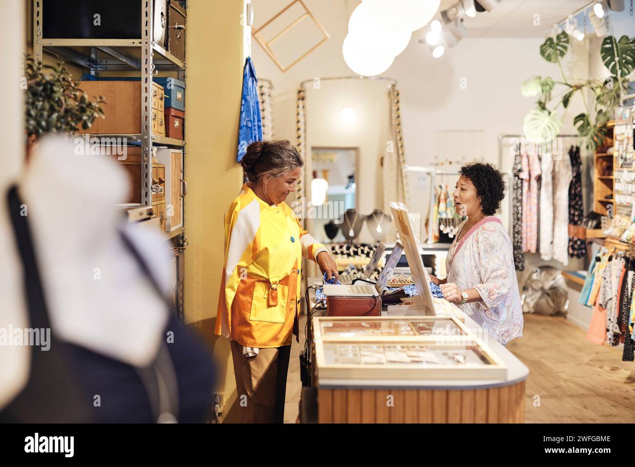 Female customer talking with disabled saleswoman while standing at ...