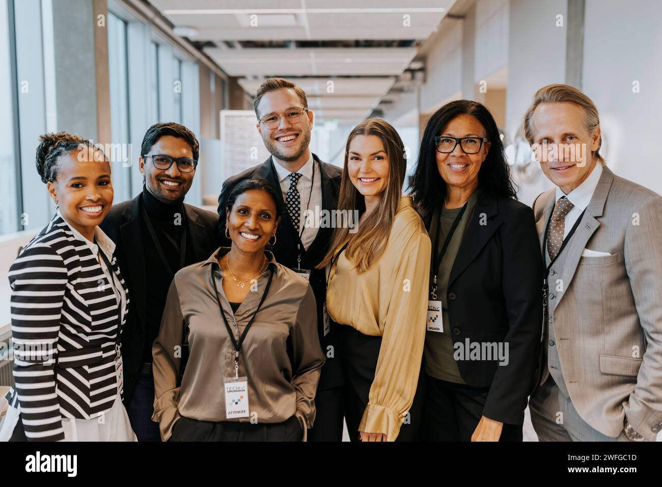Portrait of smiling multiracial delegates standing in corridor Stock ...