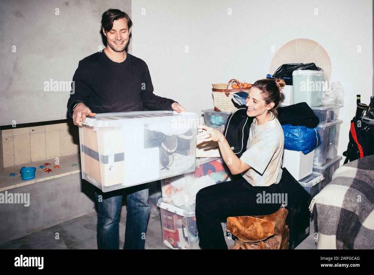 Happy couple helping each other during relocation of house Stock Photo ...