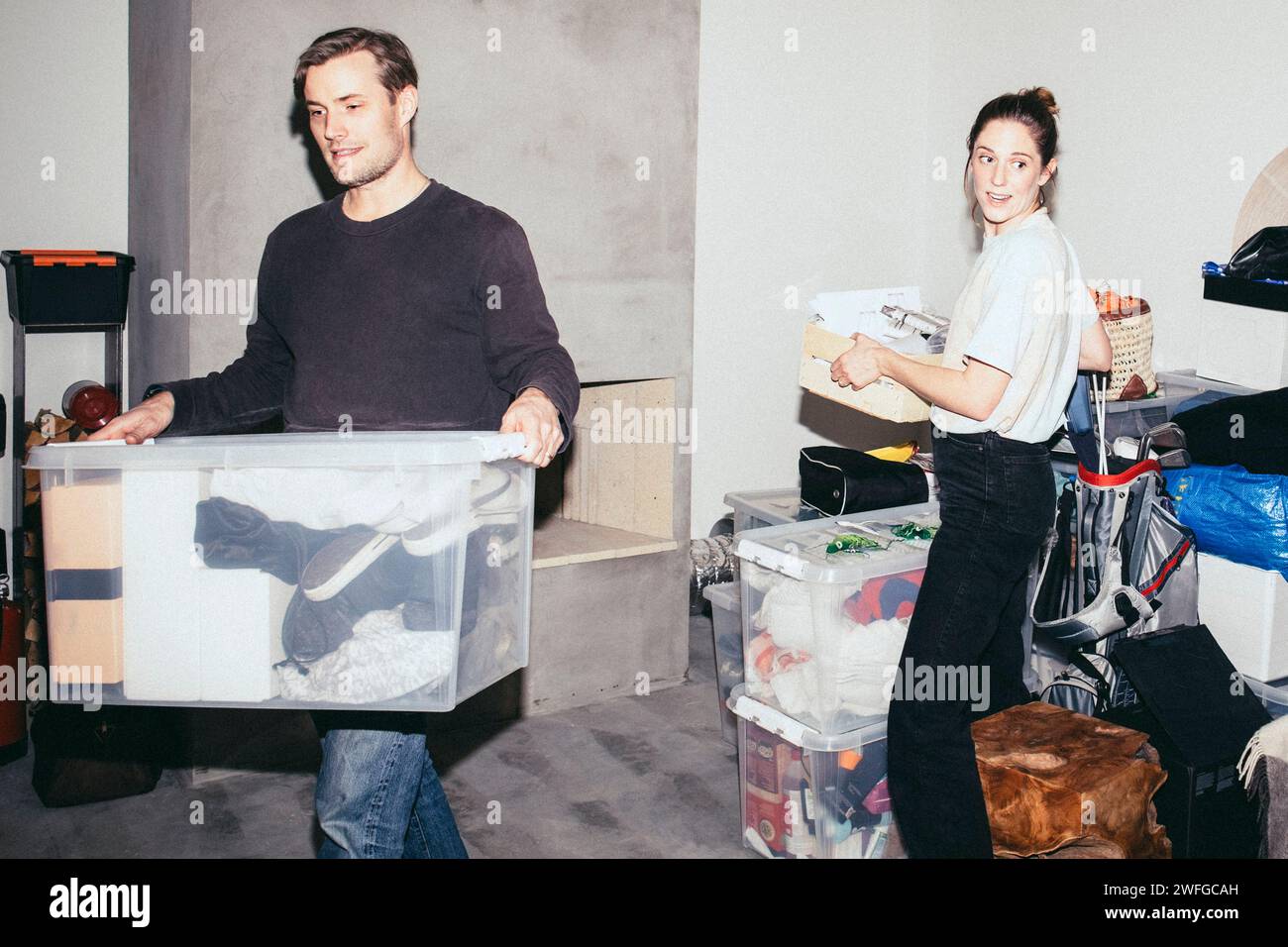 Man and woman helping each other while picking boxes during relocation ...