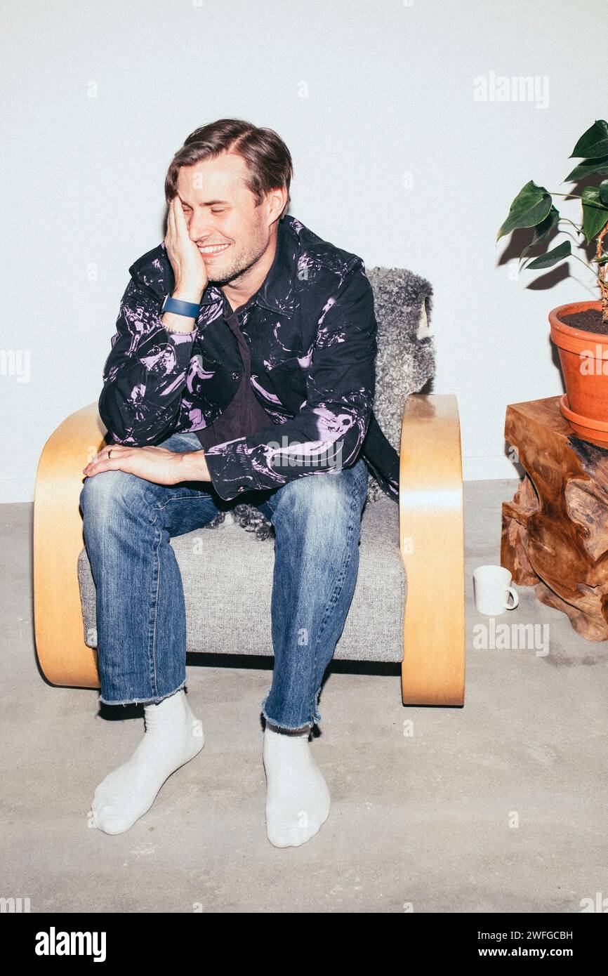 Smiling man sitting home hi-res stock photography and images - Alamy