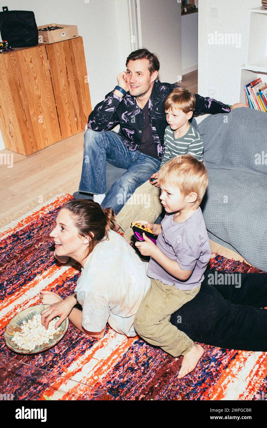 High angle view of kids playing video game while sitting with parents ...