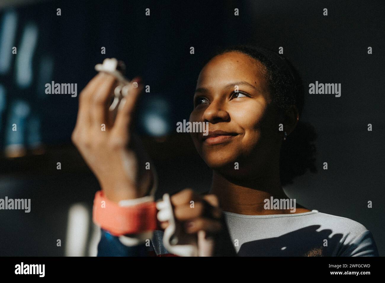 Smiling teenage girl day dreaming in school gymnasium Stock Photo - Alamy