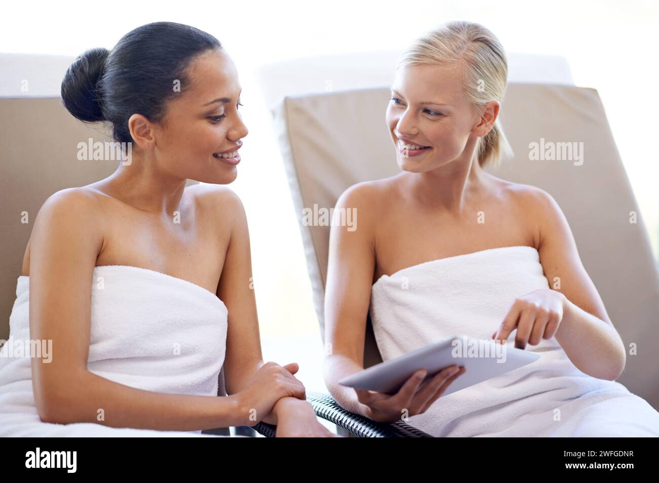 Women, tablet and spa with talk and facial menu or hotel beauty ...