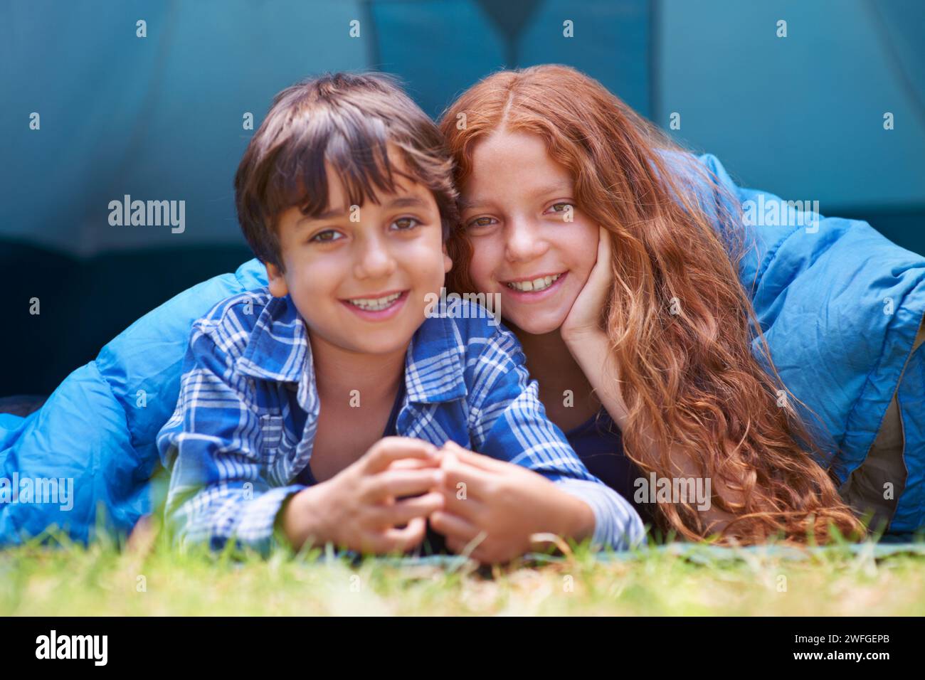 Portrait, love and children lying with blanket for camping, comfort and ...