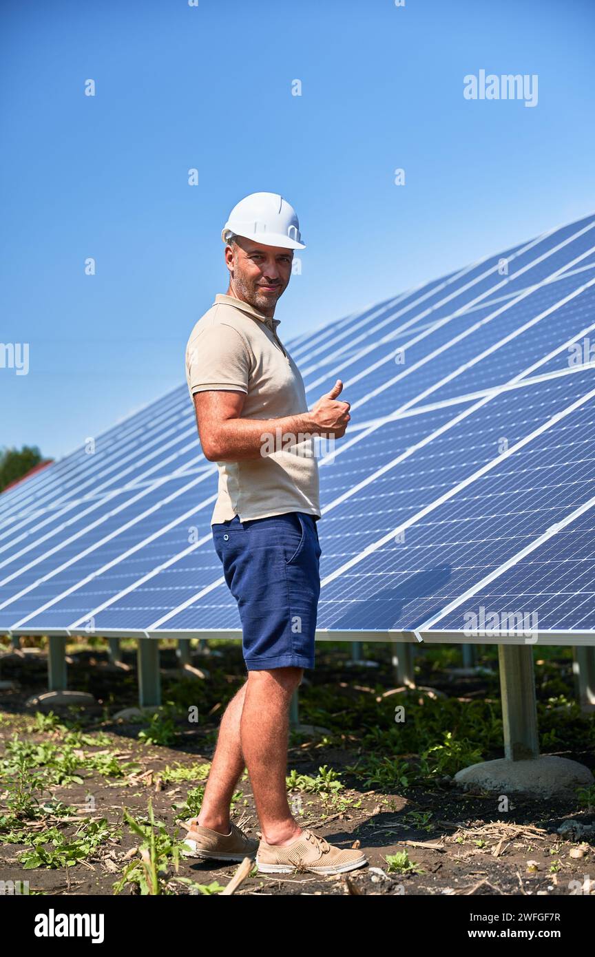 Enthusiastic man happy about new solar panel. Male adult in helmet ...