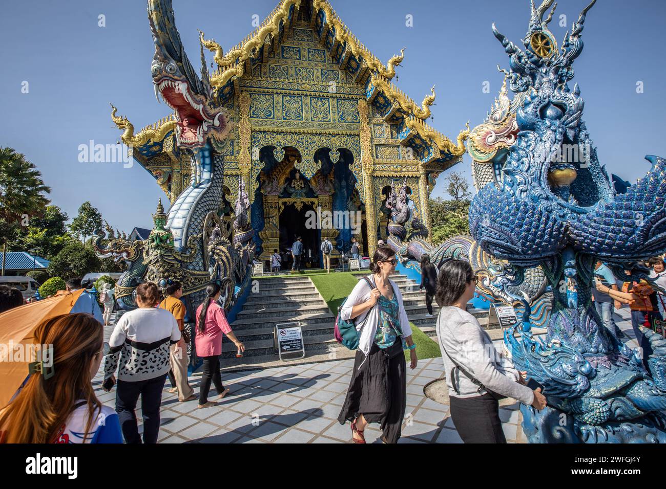 Tourists walk in and out of the Blue Temple. Wat Rong Suea Ten (Temple ...
