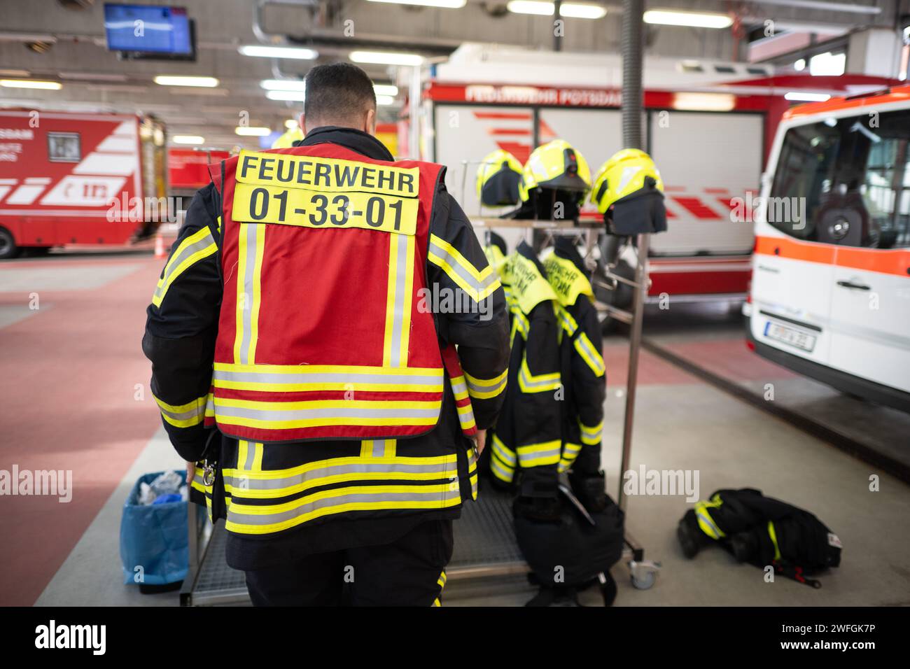 Potsdam, Germany. 30th Jan, 2024. A firefighter gets dressed before an ...