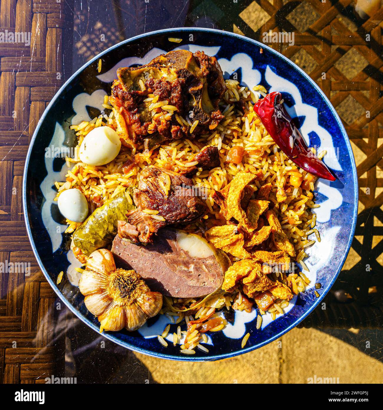 Top view of a plate with Uzbek oriental pilaf with pieces of lamb ...
