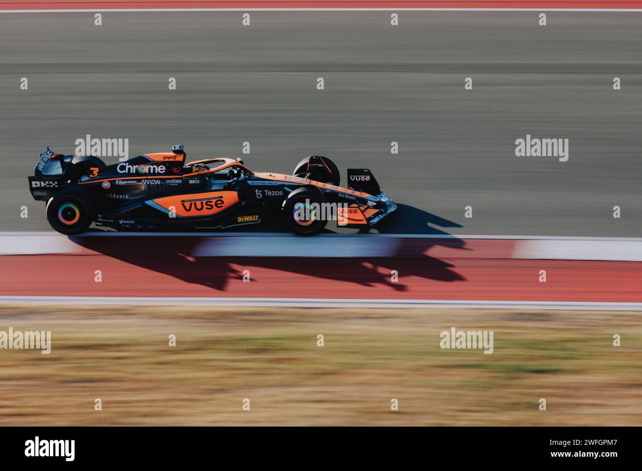 A fast-moving racing car speeds along a racetrack, creating a dynamic ...