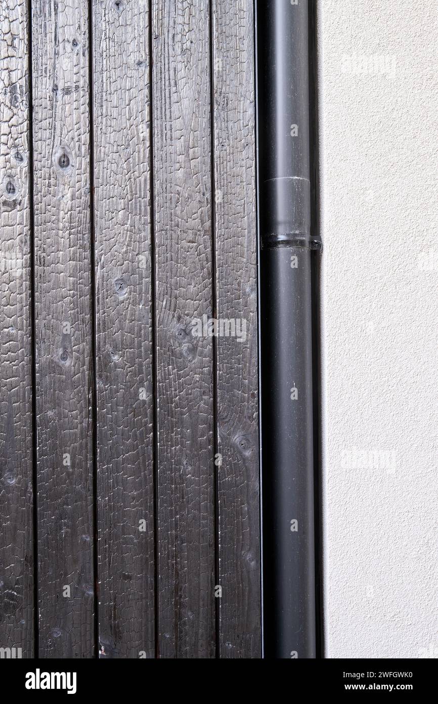 Modern rain gutter on burned wood wall Stock Photo - Alamy