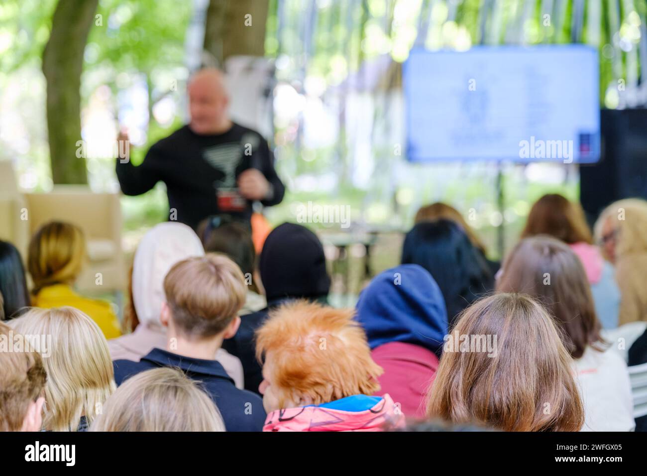 Focused audience listening to a presenter at an outdoor educational ...