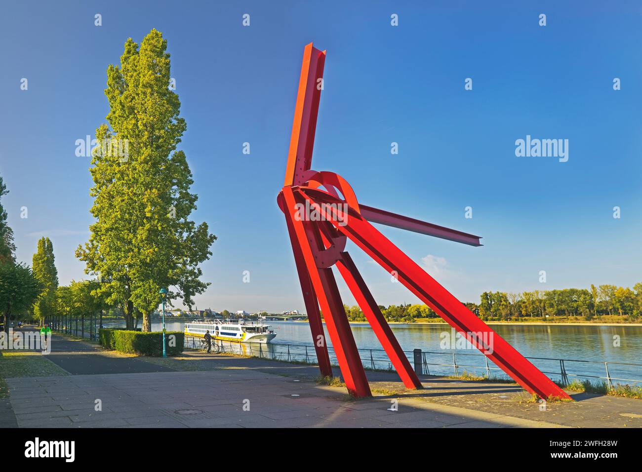 red sculpture made of steel profiles L'Allumé at river Rhine, pointing ...