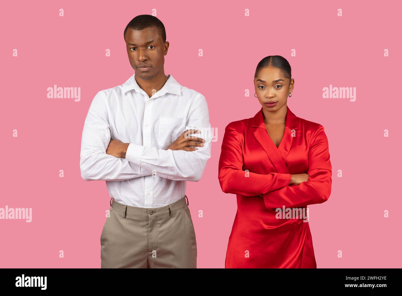 Serious black couple with arms crossed in formal attire Stock Photo - Alamy