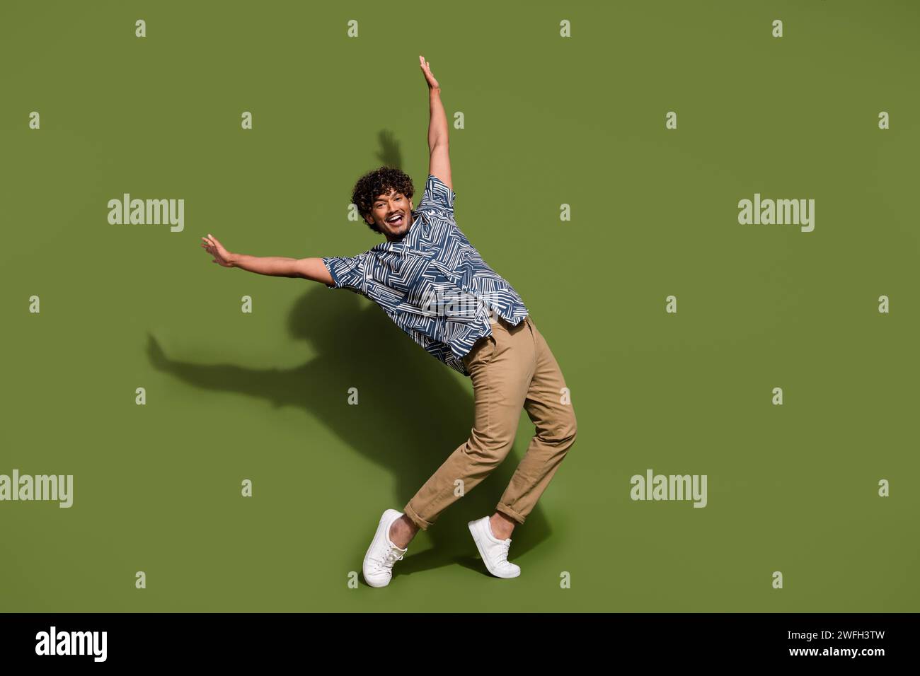Full body length photo of indian positive guy standing tiptoes raised ...