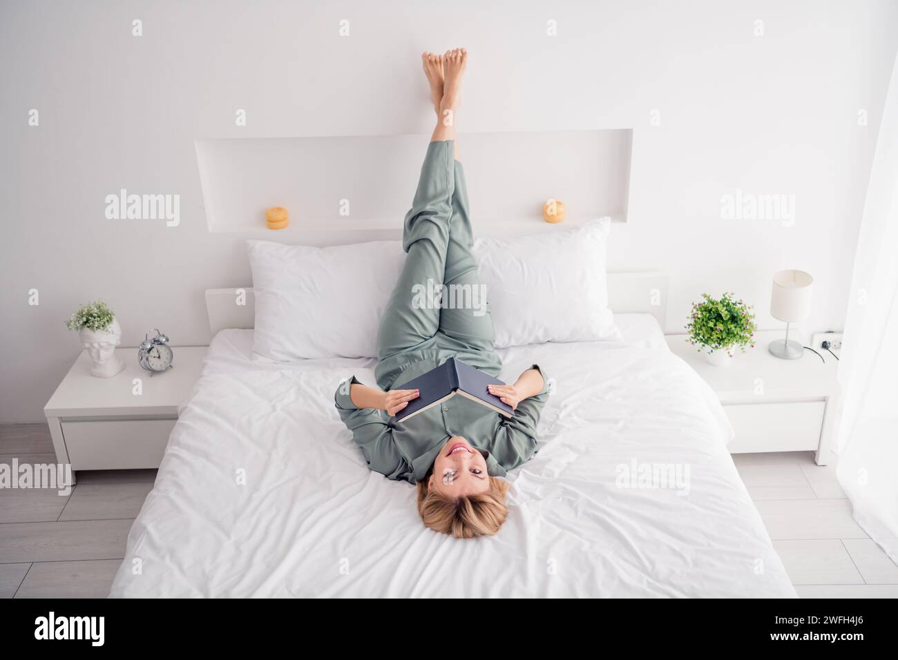 Photo of young cute smiling girl laying down the bed with her book ... Photo of young cute smiling girl laying down the bed with her book ...