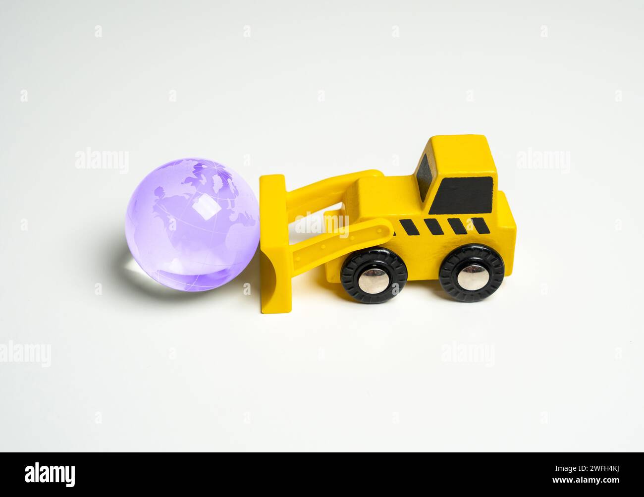 A bulldozer pushes the earth globe. Movement and progress forward ...