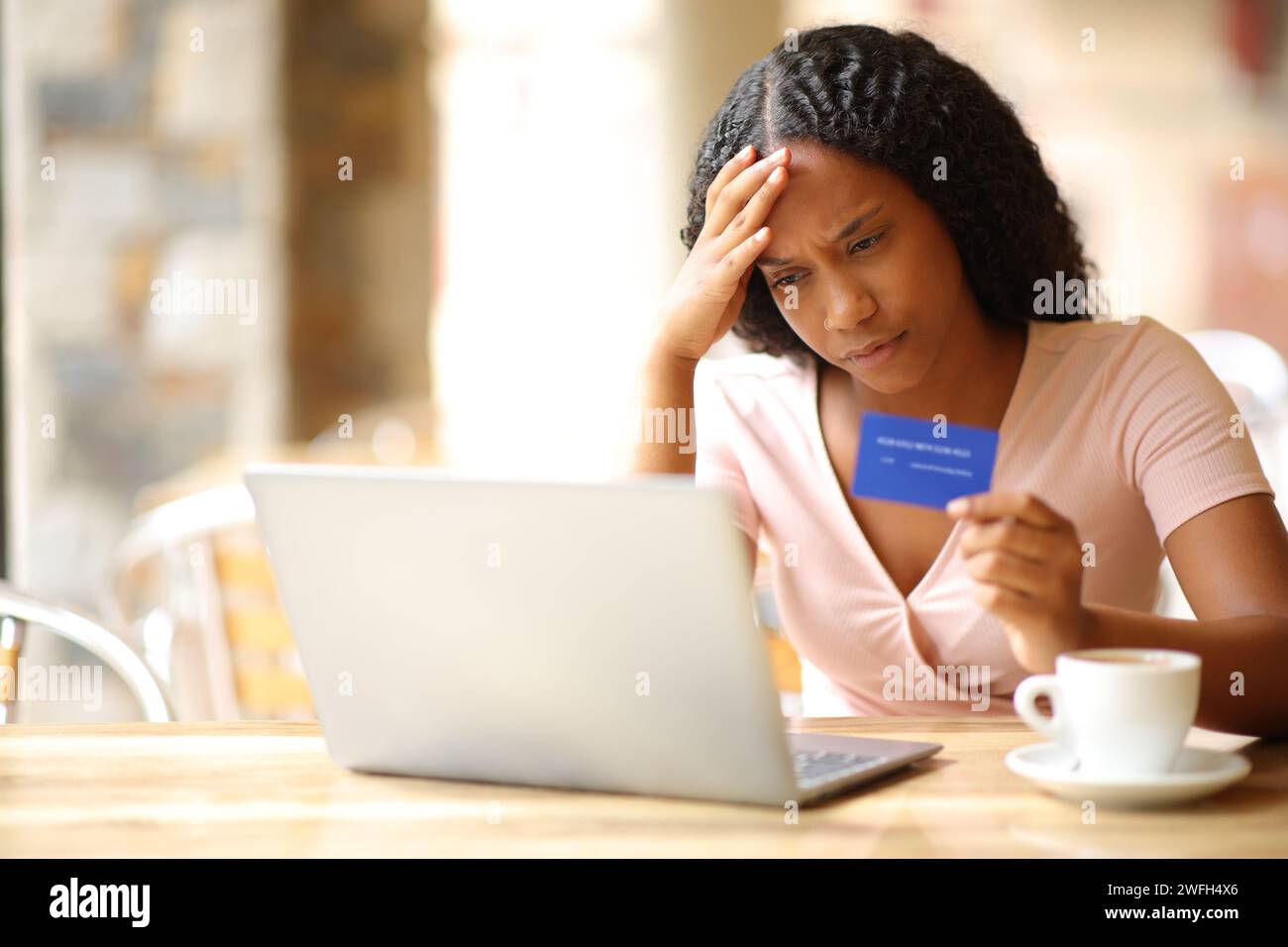 Worried black woman having problem buying online in a coffee shop ...