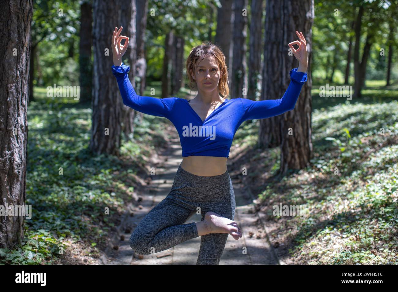 young woman performing yoga in forest Stock Photo - Alamy