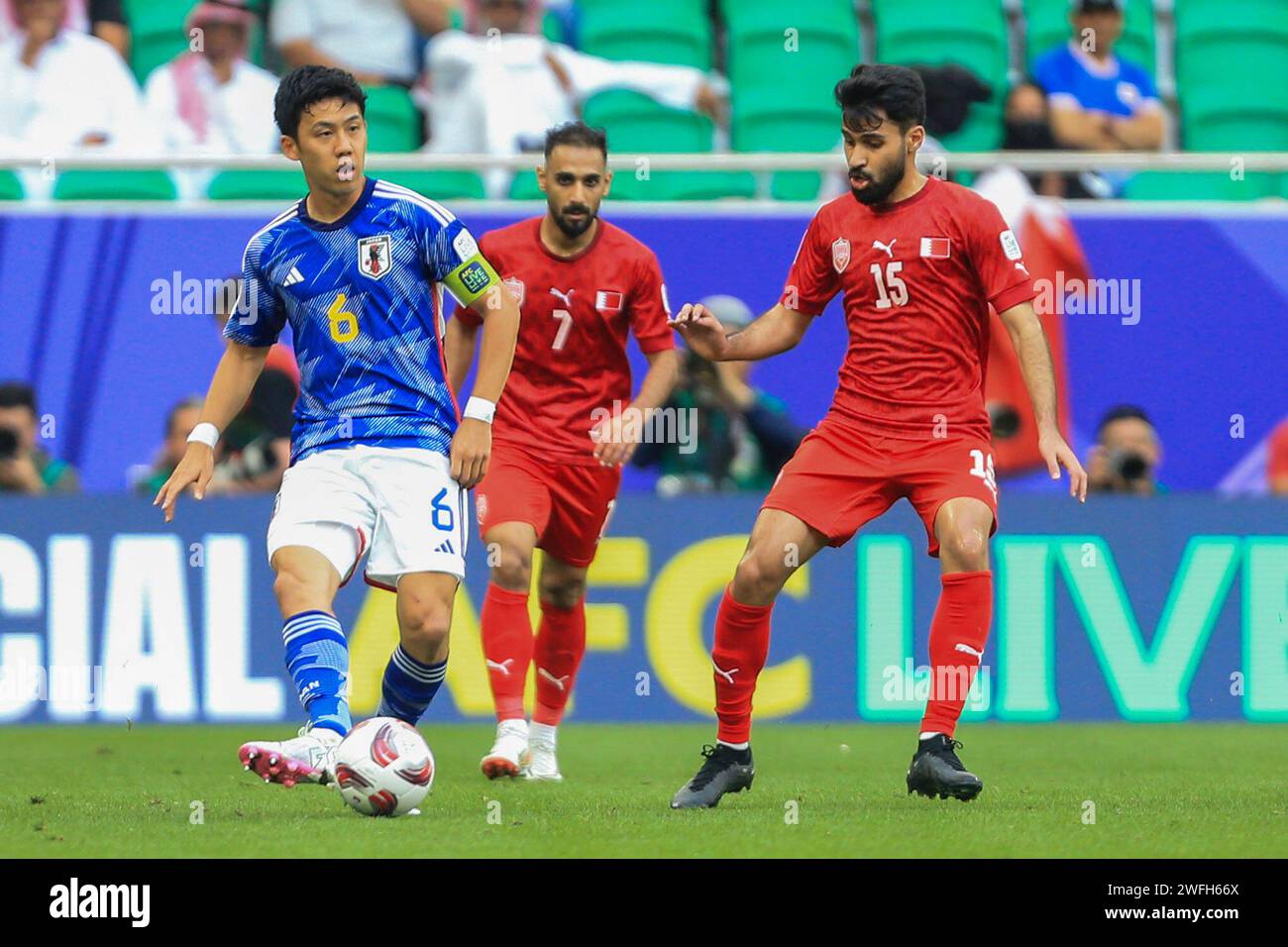 Japan's Wataru Endo, left, controls the ball next to Bahrain's Jasim ...