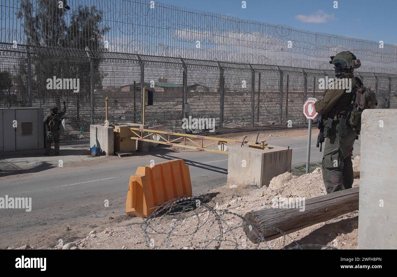 An Israeli soldier stands guard at the Nitzana crossing where trucks ...