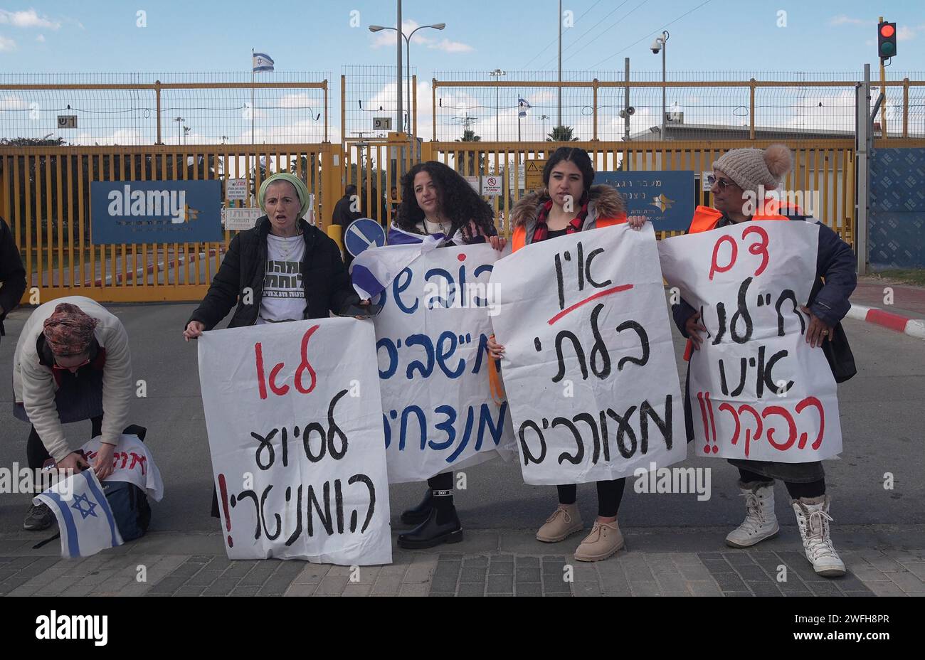 Israeli protesters hold placards as they gather by the border fence ...
