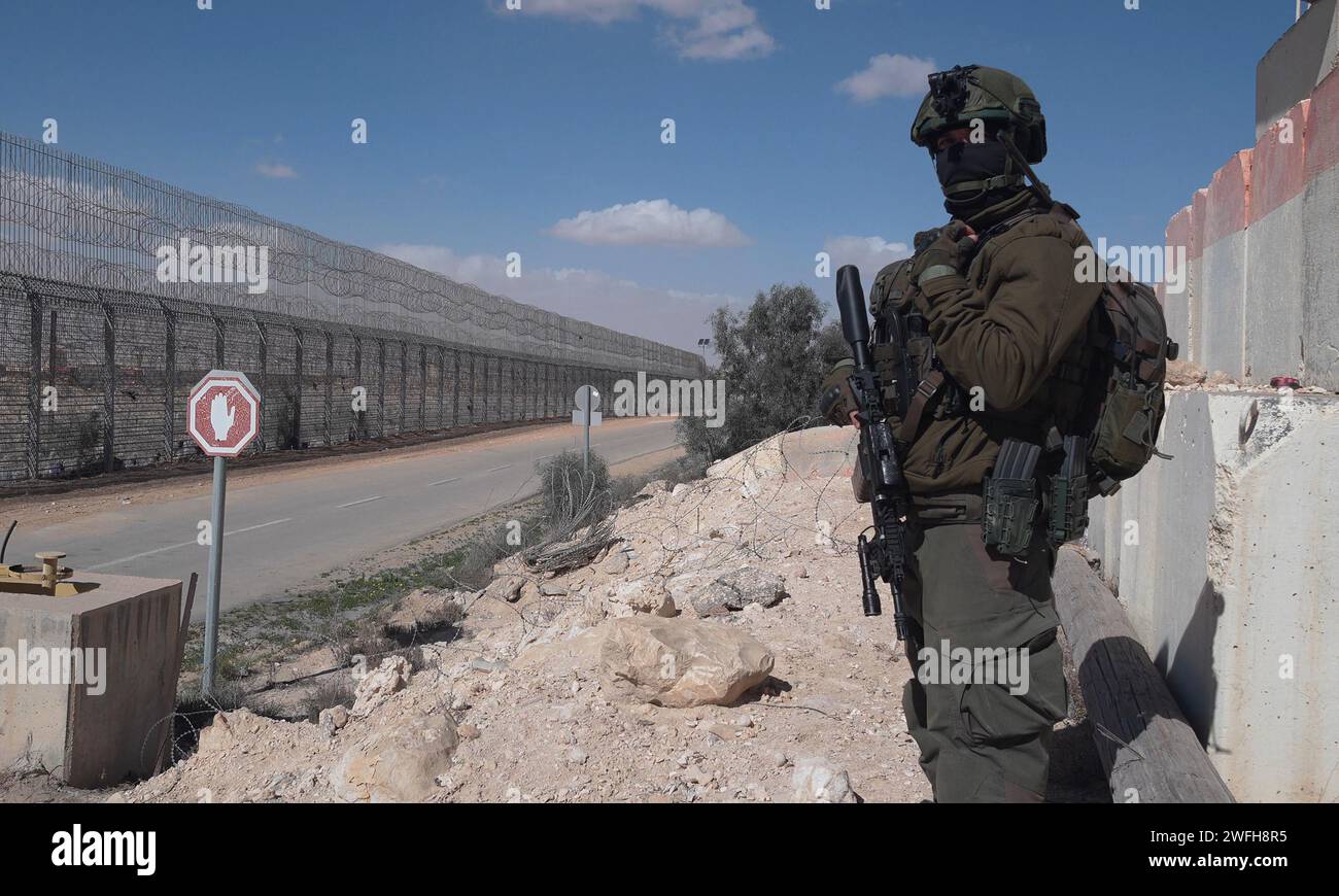 An Israeli soldier stands guard at the Nitzana crossing where trucks ...