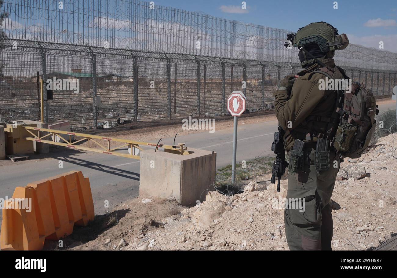 An Israeli soldier stands guard at the Nitzana crossing where trucks ...