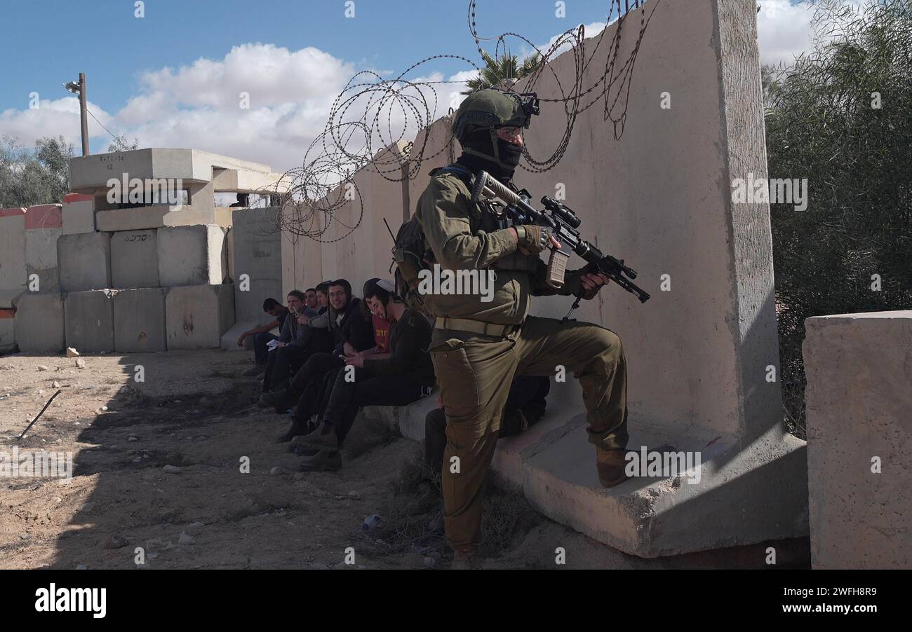 An Israeli soldier stands guard as Israeli protesters gather by the ...