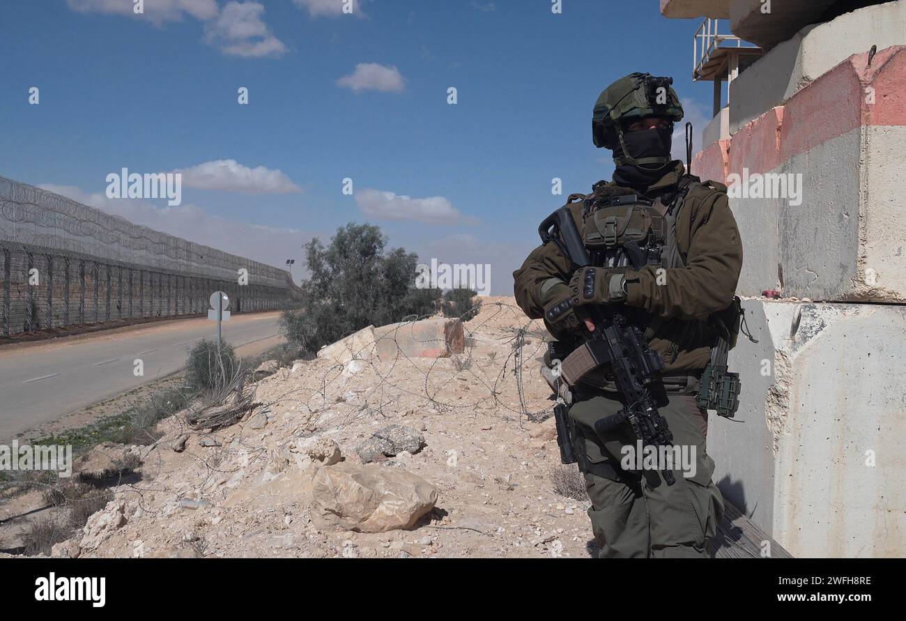 An Israeli soldier stands guard at the Nitzana crossing where trucks ...