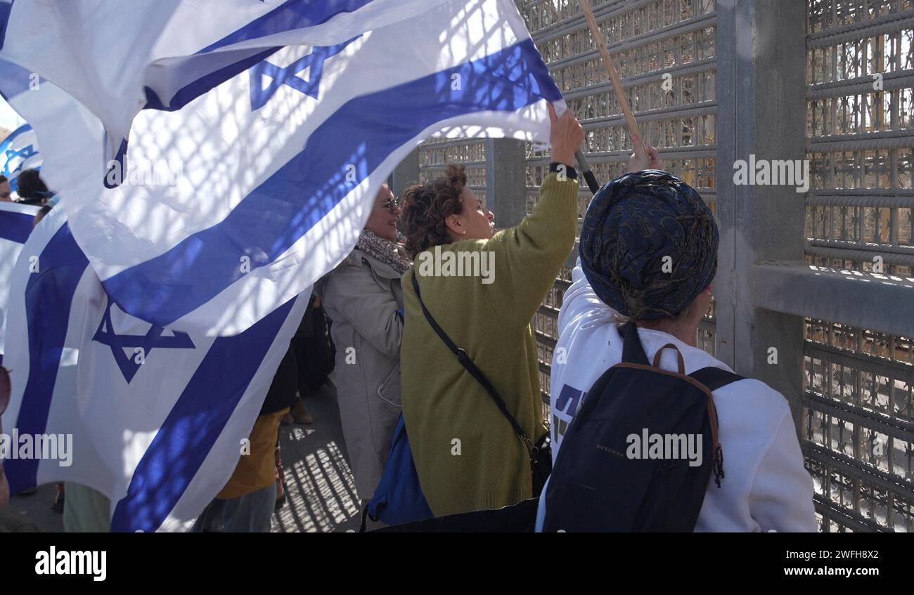 Israeli protesters hold Israeli flags as they gather by the border ...